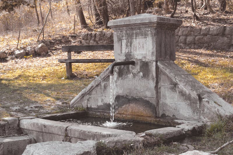 Water Flowing from the Tap of the Stone Water Source in the Park Stock ...