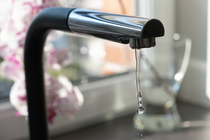 Water Flows from a Black Tap in a Kitchen with a Window Stock Image ...