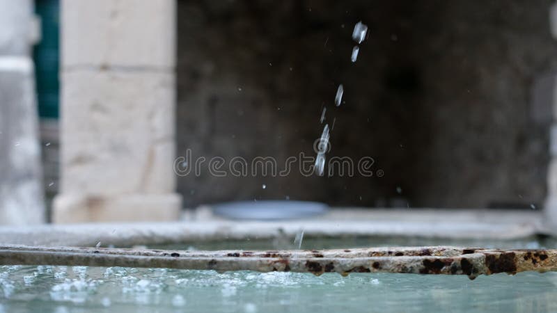 Water Flows in a Fountain in a Village Square. Bubbling Water Stock ...