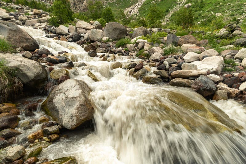 Water Flows Over Rocks at the Bottom of a Mountain Waterfall Stock ...