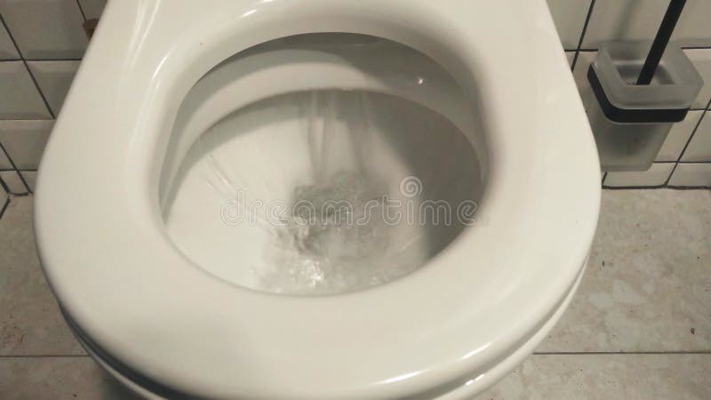 The Water is Flushed into the Toilet. Toilet Flush. Close-up on the ...