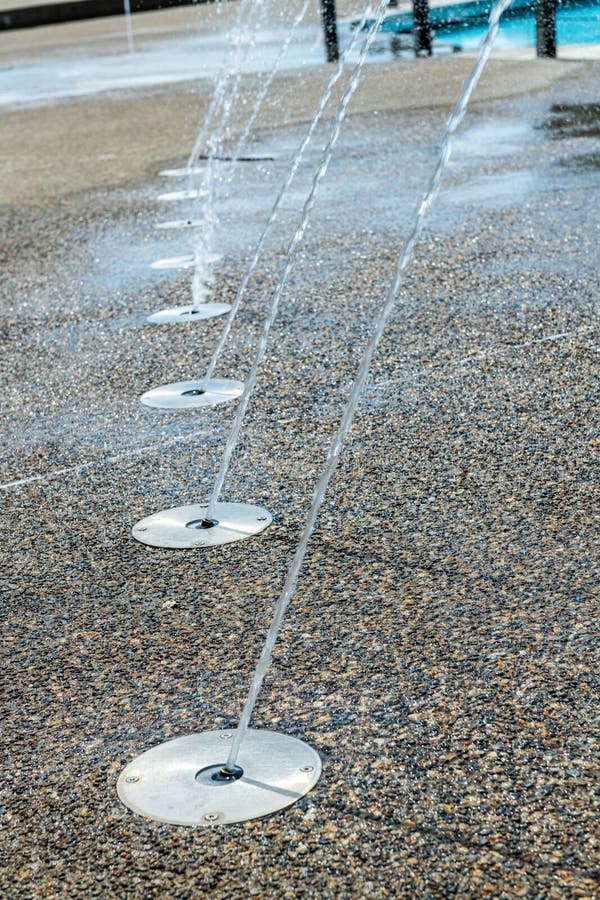 Water jets on the sidewalk stock image. Image of fountain - 177426719