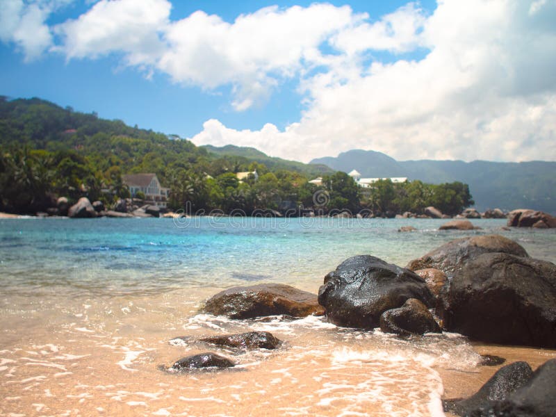 Water Lapping Against Rocks on a Seychelles Beach during a Sunny Stock ...