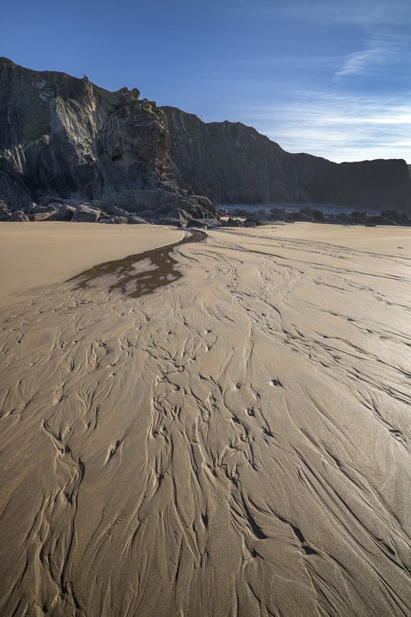 Water patterns in the sand stock photo. Image of shore - 345301438