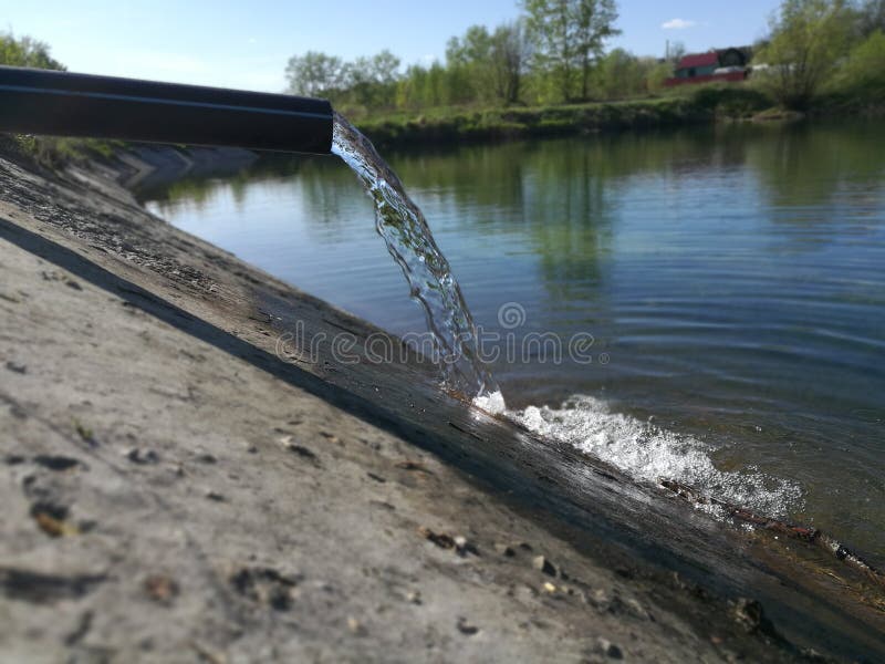 Water from the Pipe Flows into a Clear Lake Stock Photo - Image of ...