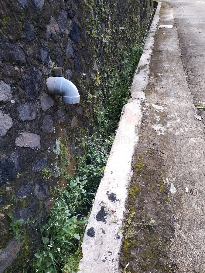 Water Pipe in Stone Wall stock photo. Image of yard - 242142120