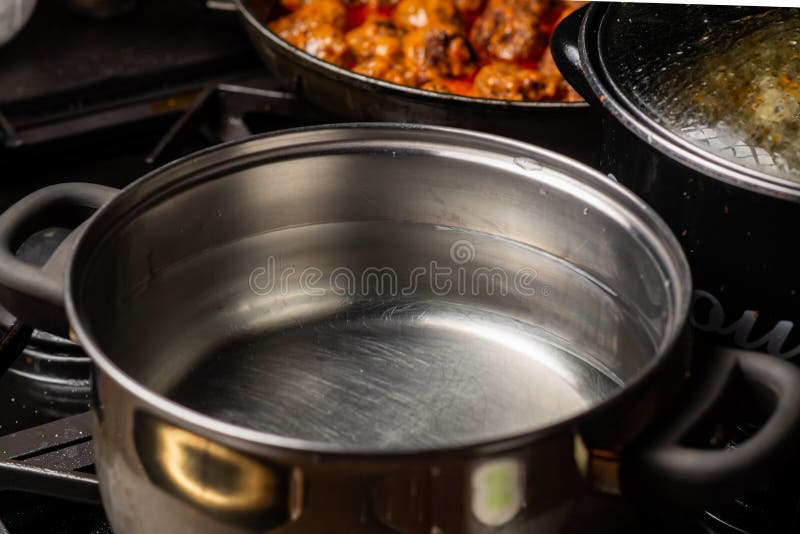Water in a Pot is on the Stove in the Kitchen. Preparation for Boiling ...
