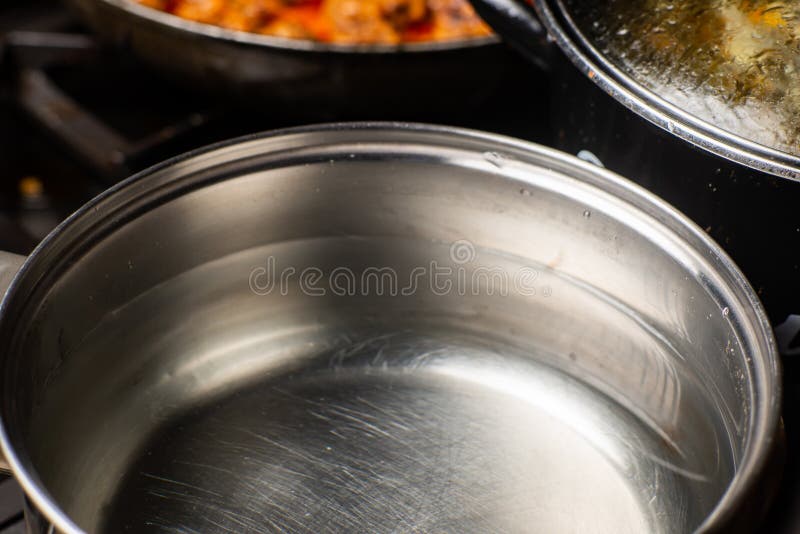 Water in a Pot is on the Stove in the Kitchen. Preparation for Boiling ...