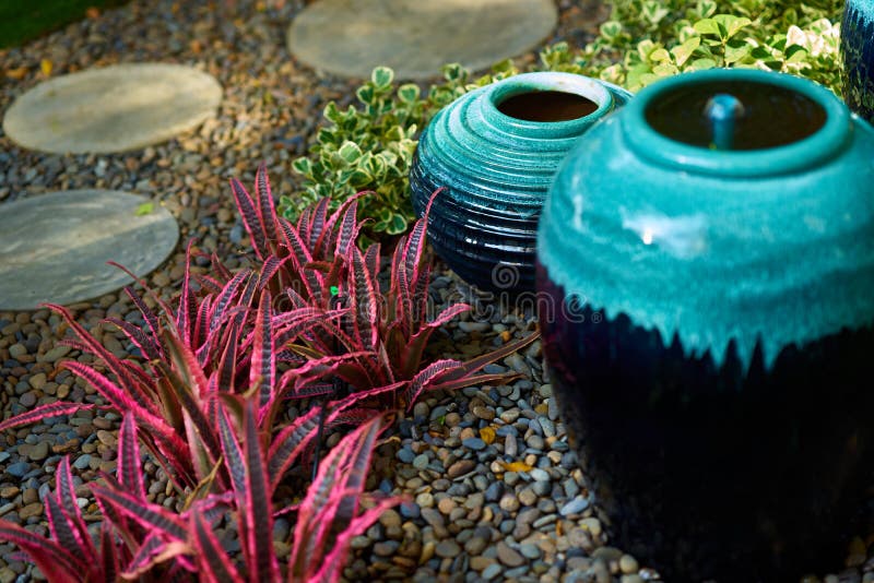 Water Pots with Small Plants in Decorated Garden Stock Photo - Image of ...