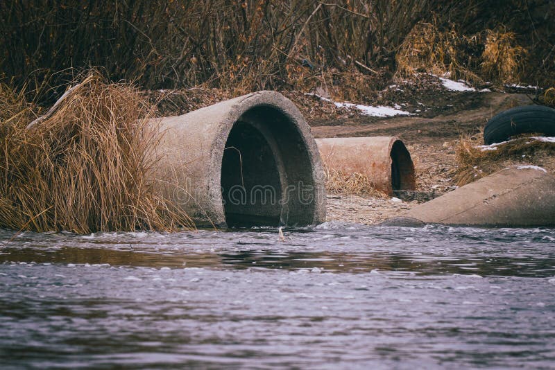 The Water on the River Flows from Large Pipes. Dam on River Stock Photo ...