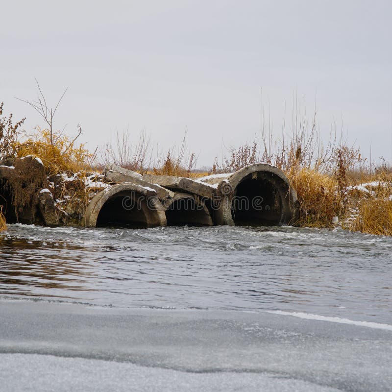 The Water on the River Flows from Large Pipes. Dam on River Stock Photo ...