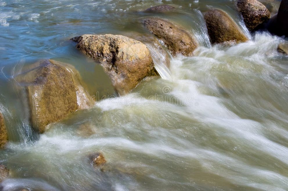 Water rushing over rocks stock photo. Image of current - 7799984