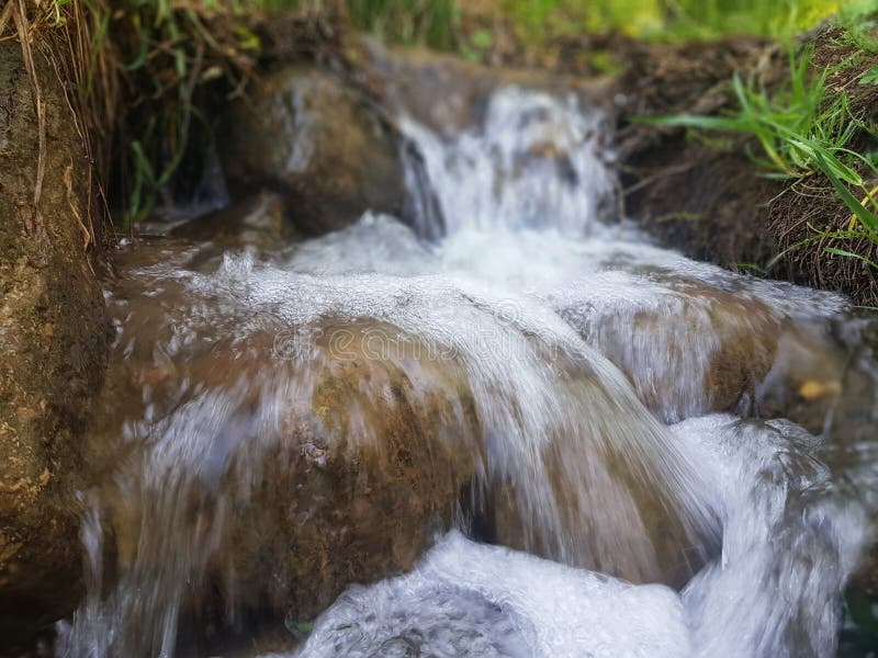 The Water Source Flows Down the Rocks into the River Stock Photo ...