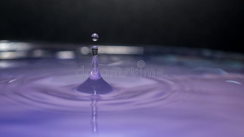 Water Splash in Colorful Background with a Drop of Water Flying from ...