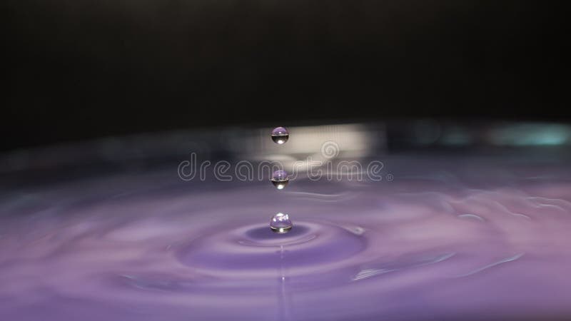 Water Splash in Colorful Background with a Drop of Water Flying from ...
