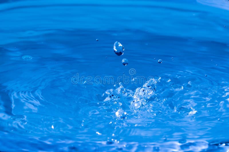 Water Splash in Dark Blue Color with a Drop of Water Flying from Stock ...