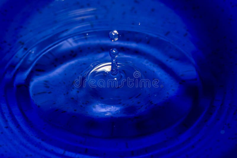 Water Splash in Dark Blue Color with a Drop of Water Flying from Stock ...