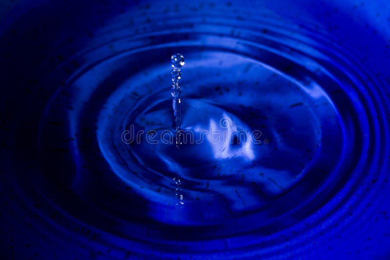 Water Splash in Dark Blue Color with a Drop of Water Flying from Stock ...