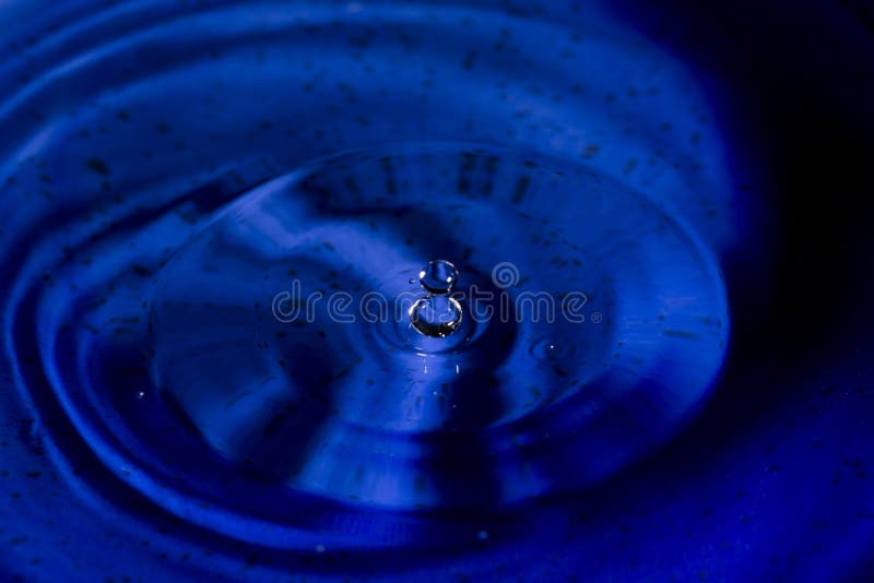 Water Splash in Dark Blue Color with a Drop of Water Flying from Stock ...