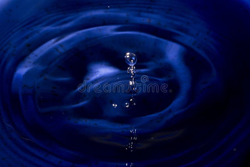 Water Splash in Dark Blue Color with a Drop of Water Flying from Stock ...