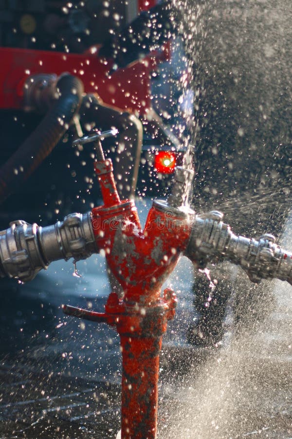 Water Splashes from the Fire Hose and Hydrant Connections. Firefighters ...