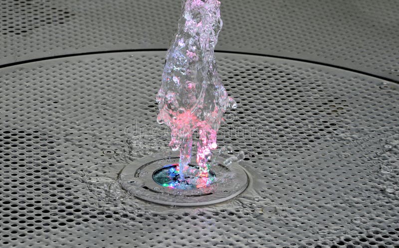 Water Sprays Backlit by Colored Lights Alternating at Night with a ...