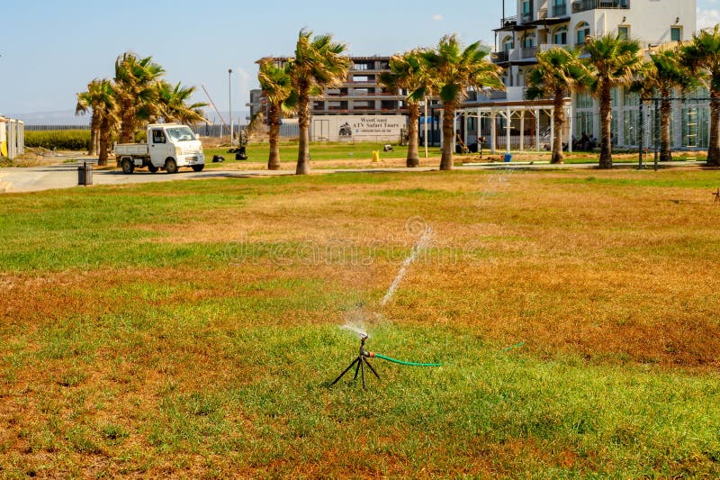 Water Sprinkler Spraying Water on a Parched Lawn in Summer Stock Image ...