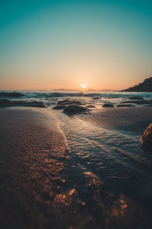 A Water Stream Flowing in the Sand of the Beach during a Sunset Stock ...