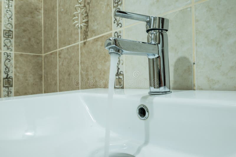 A Water Tap with Clear Water Running Down into the Sink Stock Photo ...