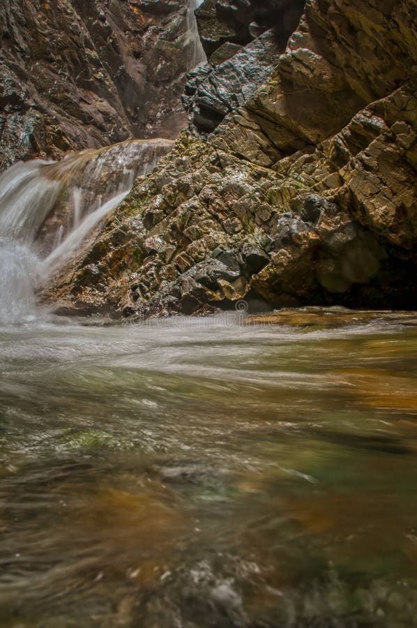 Water Flows Thru a Textured Rock Face, Forming a Dynamic Waterfall ...