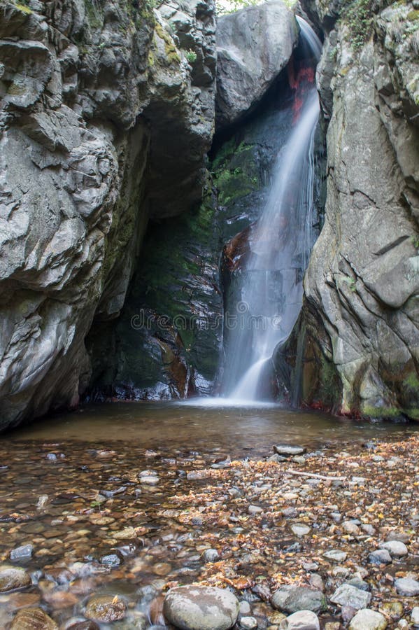 Waterfall between Big Rocks. Stock Photo - Image of field, orange ...
