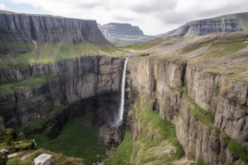 Waterfall Cascading Over Towering Cliff, with View of the Valley Below ...
