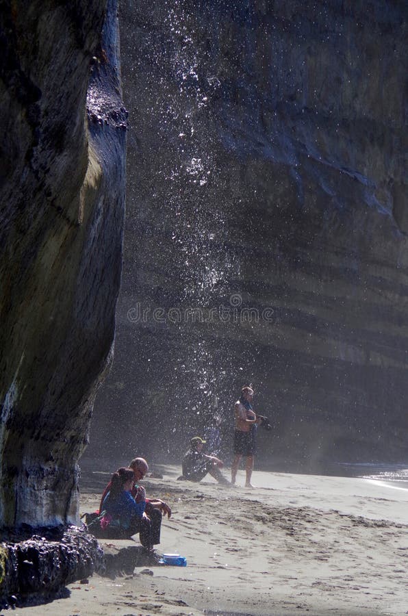 Waterfall from Cliffs Onto Beach with People Editorial Photo - Image of ...