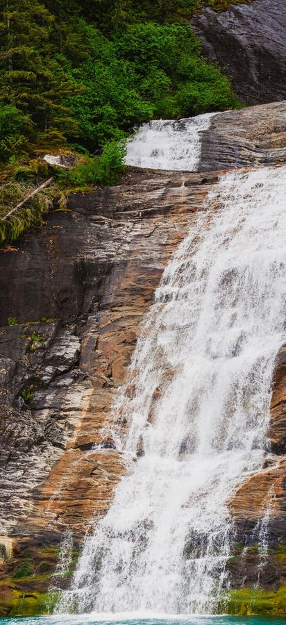 Waterfall Running Down Mountainside with Lush Greenery Stock Image ...