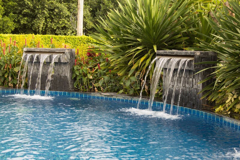 Waterfall Falling in a Blue Lagoon Swimming Pool in Hotel. Stock Photo ...