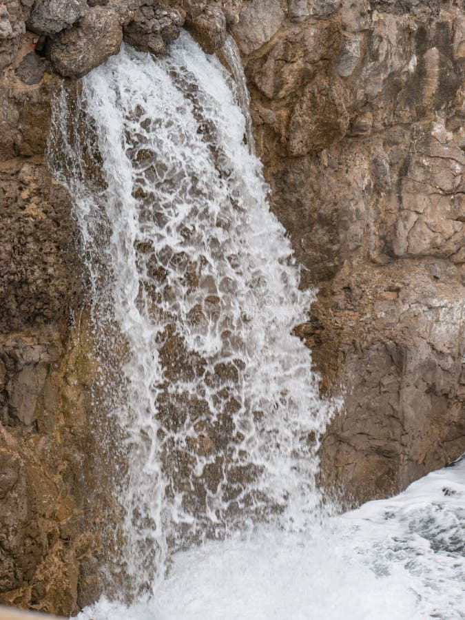 Waterfall Flowing from a Rock by the Sea Stock Photo - Image of foam ...