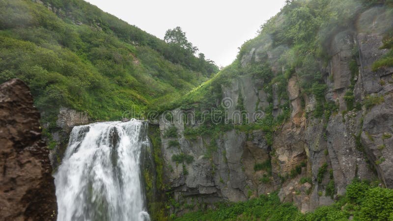 The Waterfall Flows from the Sheer Cliff. Stock Photo - Image of ...