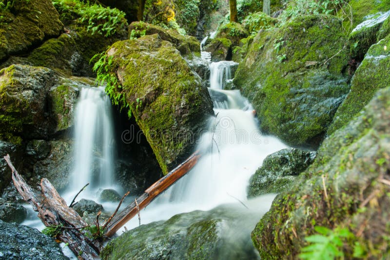 Waterfall through a Moss Covered Rock Area Stock Photo - Image of ...