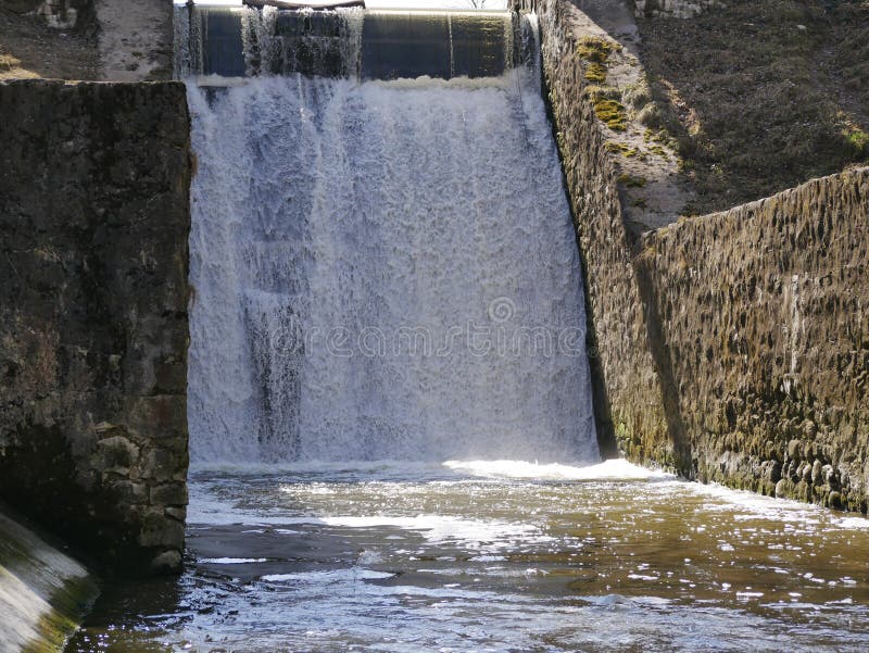 A Powerful Stream of Water Flows through the Stone Dam. Sunny Day ...