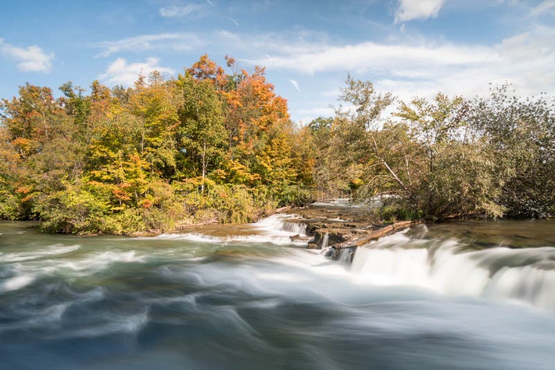 Waterfall and River with Trees in Fall Colors in the Background Stock ...