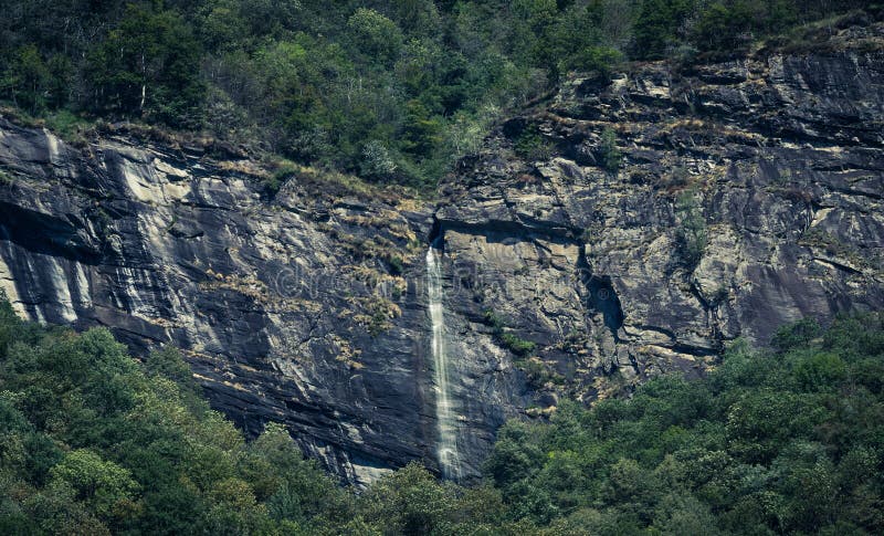 A Waterfall on a Rock Face in the Mountains Stock Image - Image of ...