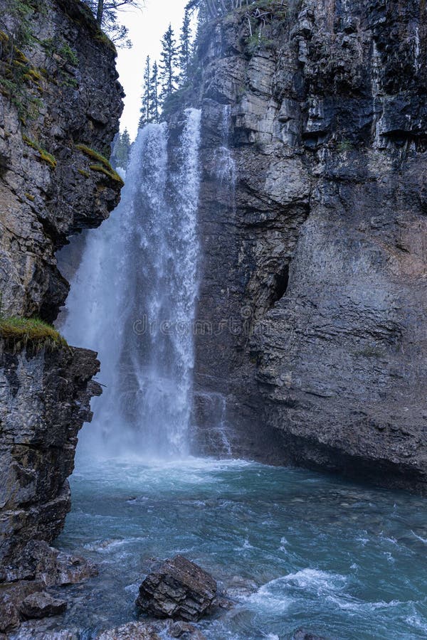 Waterfall Running into River in the Rocky Mountains Stock Photo - Image ...