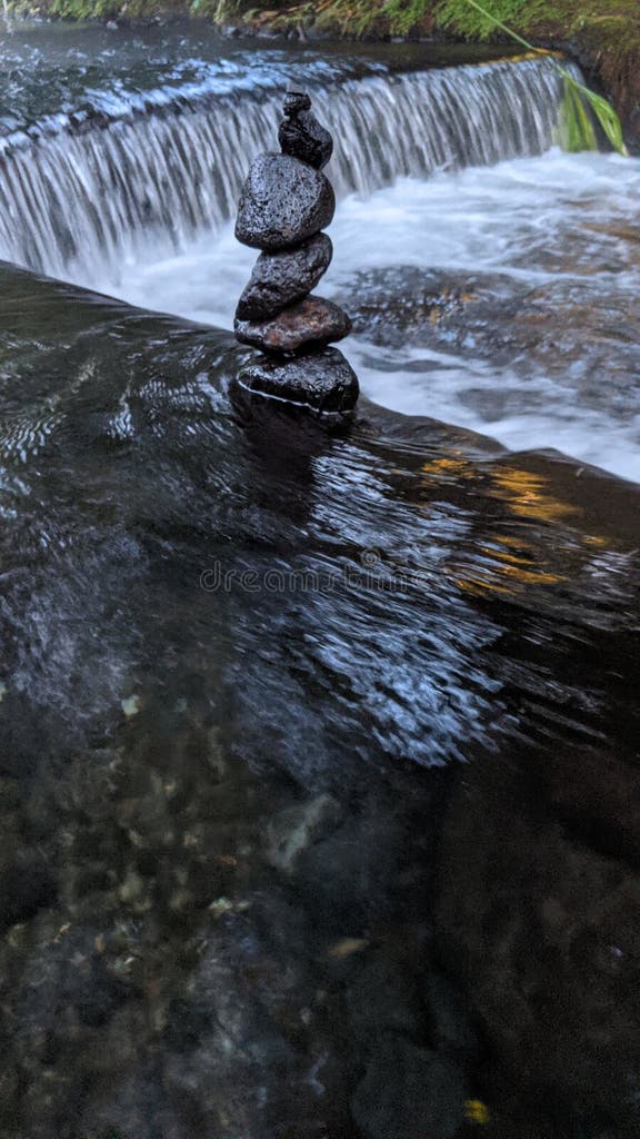 A Waterfall with a Stack of Cairn Stones Stock Photo - Image of ...