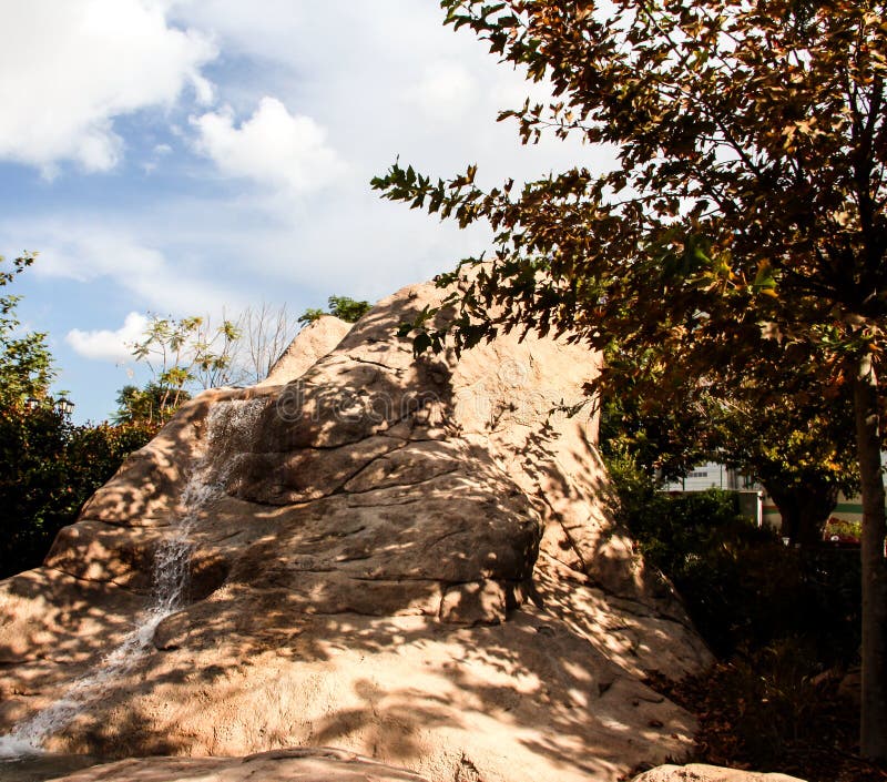 A Waterfall on a Stone Wall. a Tree Near the Waterfall Stock Photo ...