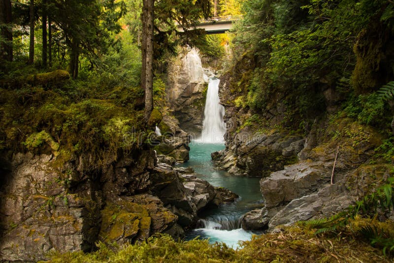 A waterfall under a bridge stock photo. Image of clear - 231245588