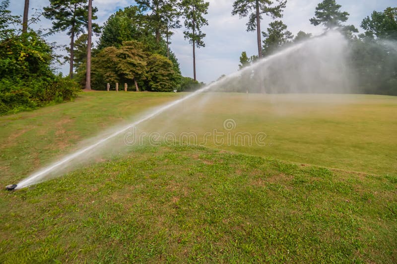 Watering green grass lawn stock photo. Image of maintenance - 34561232