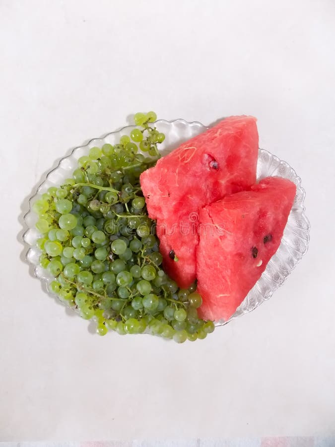 Watermelon with Grapes in a Plate on a White Background Stock Photo ...
