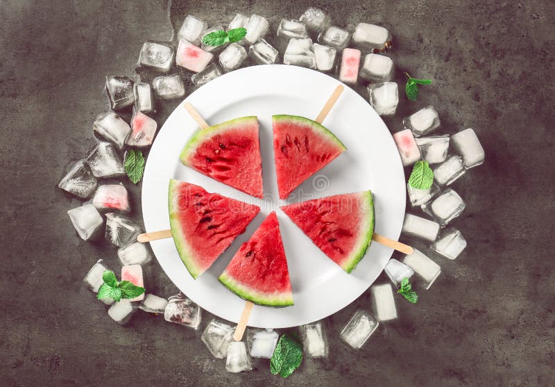 Watermelon Slices on Sticks and Ice Cubes on Table Stock Image - Image ...