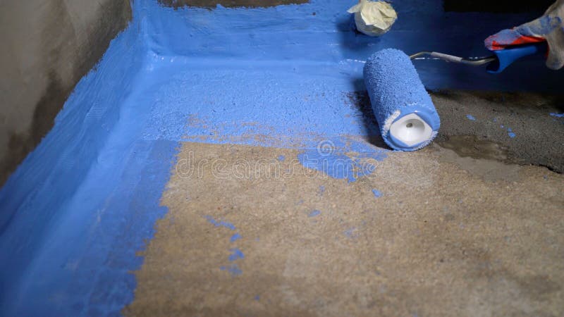 Paint Roller on a Partially Painted Floor. Waterproofing the Floor in ...