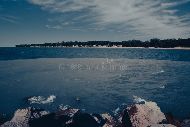 Waterside View of a Coastline with Buildings and Trees Under the Blue ...